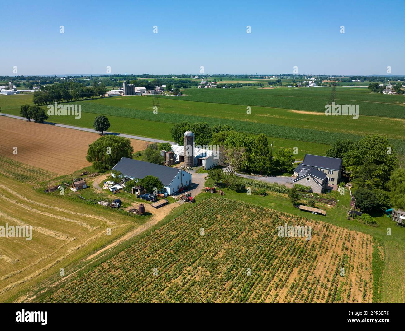 An aerial view of a farm surrounded by the lush green fields in ...