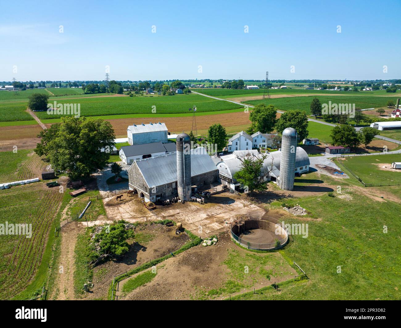 An aerial view of a farm surrounded by the lush green fields in ...