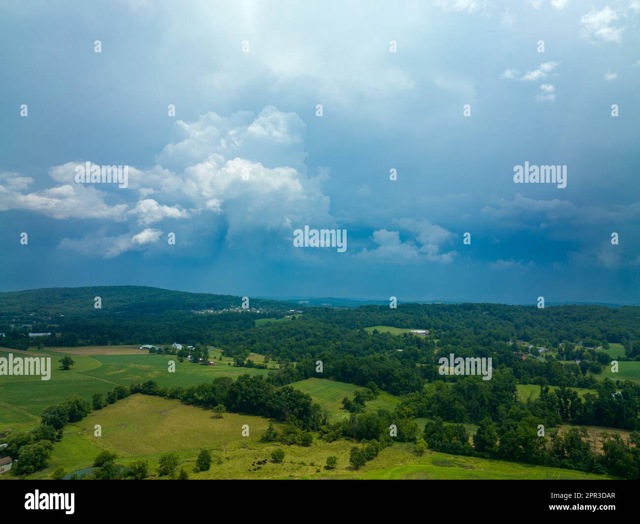 An aerial view of storm clouds gathering over the rural farmland in ...