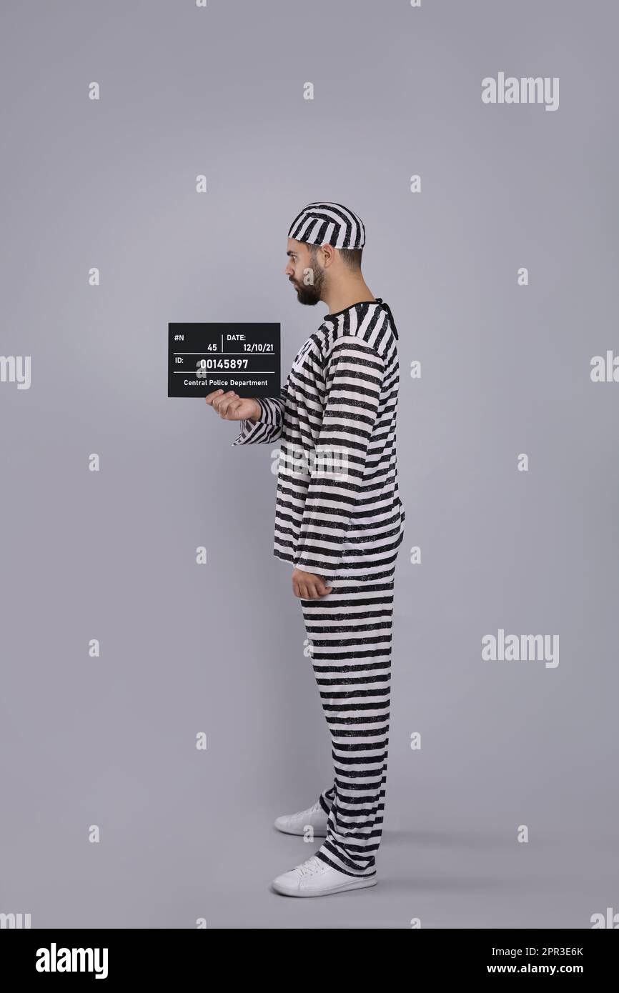 Prisoner in special uniform with mugshot letter board Stock Photo - Alamy