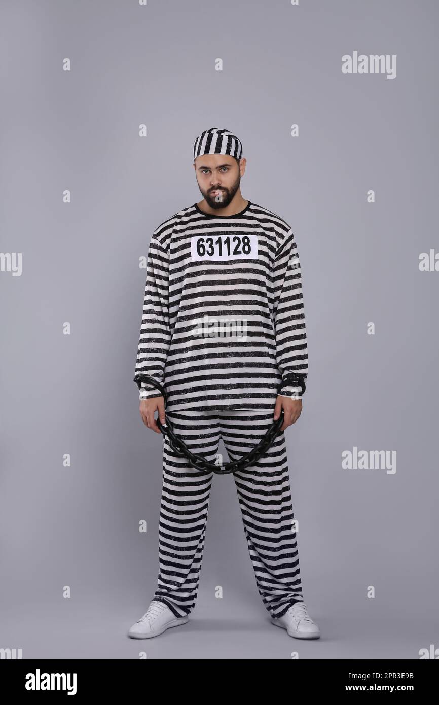 Prisoner in special uniform with chained hands on grey background Stock ...