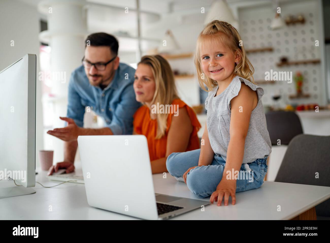 Happy family parent and child at home working on the computer. Business ...