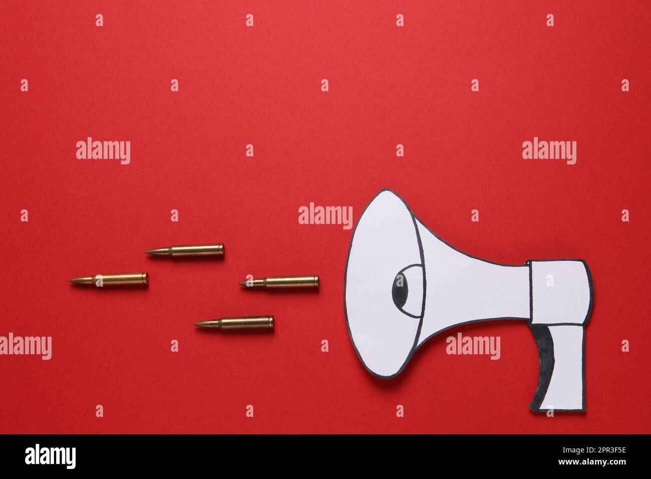 Paper loudspeaker and bullets on red background, flat lay with space ...