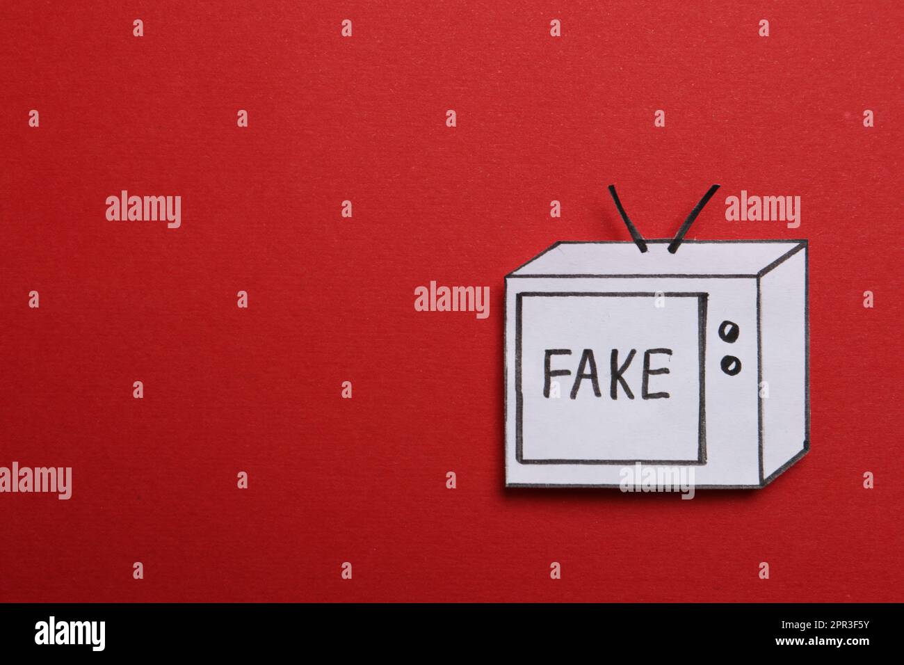 Top view of paper TV with word Fake on red background, space for text ...