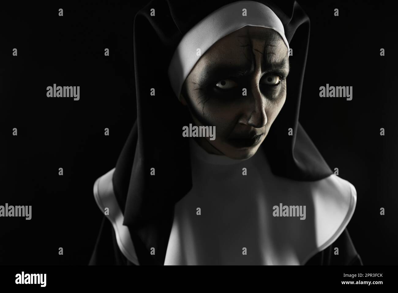 Portrait of scary devilish nun on black background. Halloween party ...