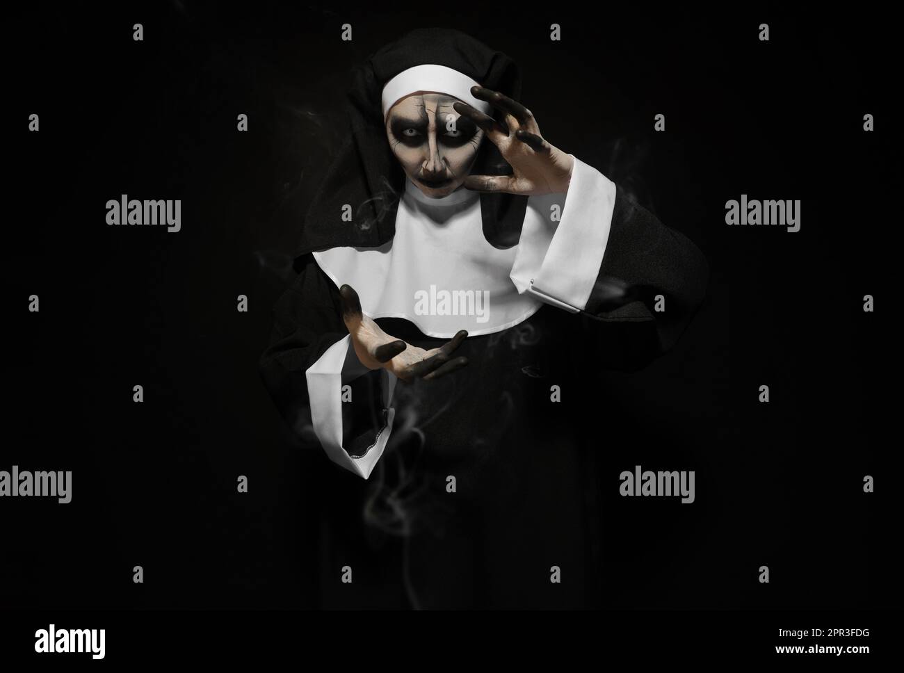 Portrait of scary devilish nun on black background. Halloween party ...