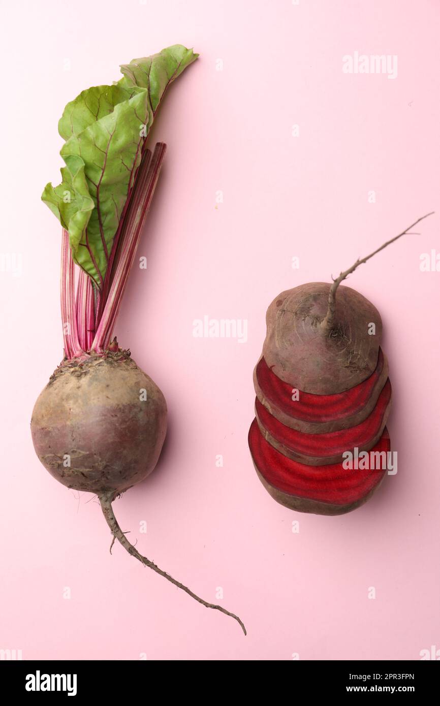 Whole and cut fresh red beets on pink background, flat lay Stock Photo ...