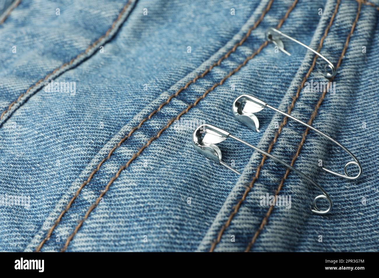 Closeup view of metal safety pins on clothing Stock Photo - Alamy