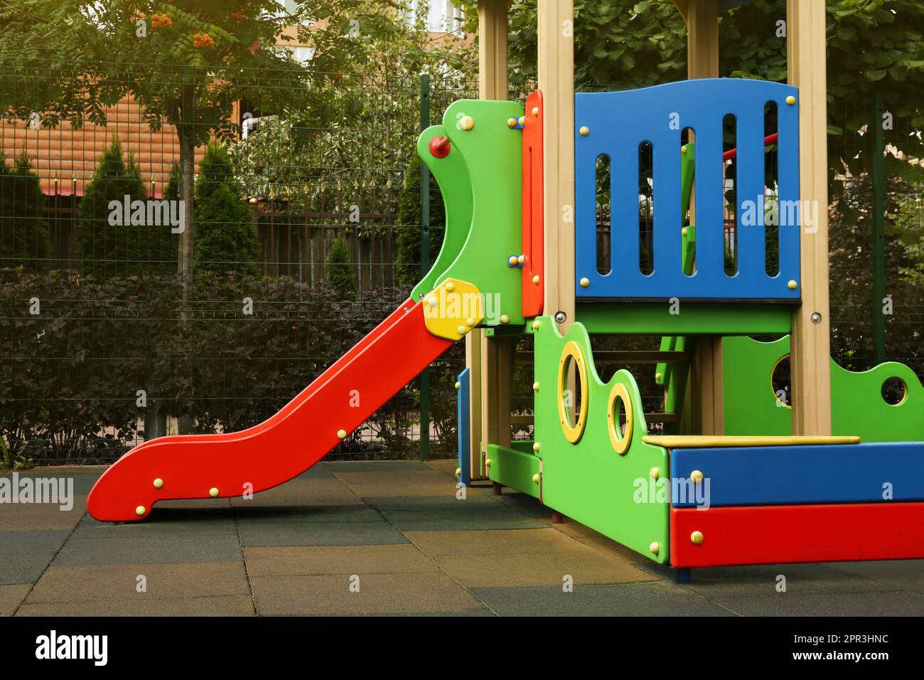 Empty outdoor children's playground with slide near fence Stock Photo ...