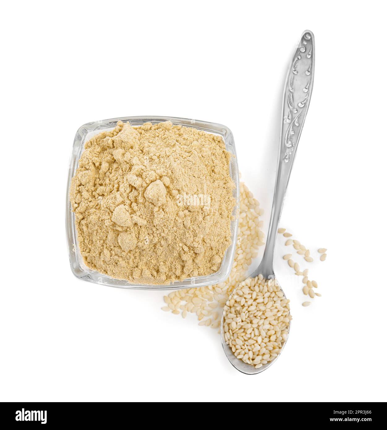 Sesame flour in glass bowl and spoon of seeds isolated on white, top ...
