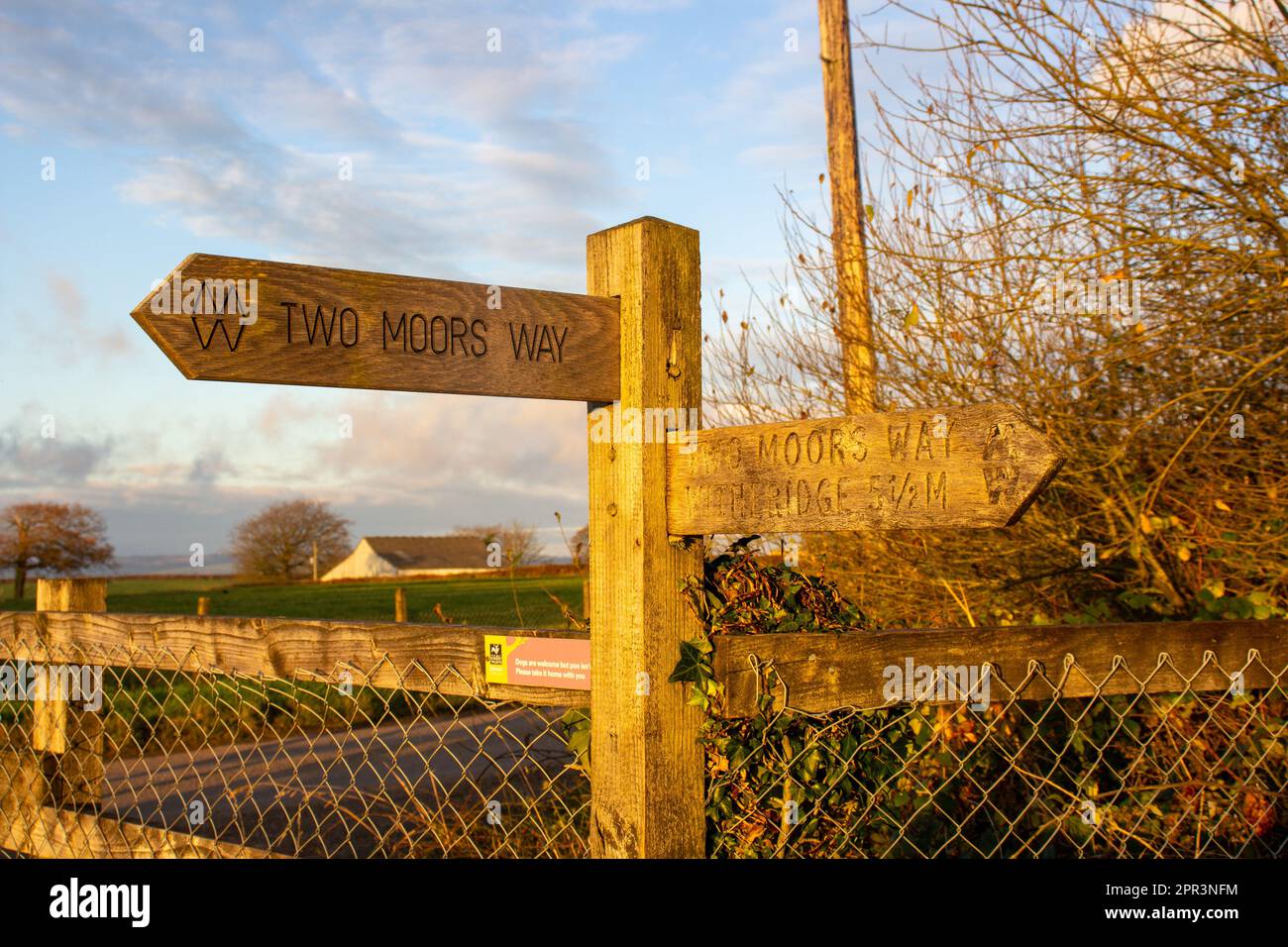 wooden TWO MOORS WAY sign post with bright Autumn sunlight and a blue ...
