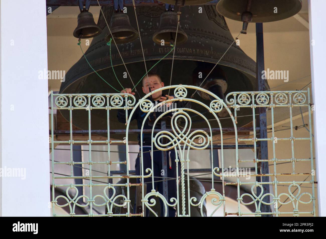 Ust-Luga. Russia. - 05.17.2020: The young bell-ringer on the bell tower ...