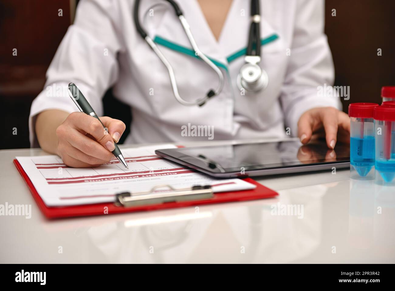 Doctor writes an X-ray analysis in the patients medical history. Close ...