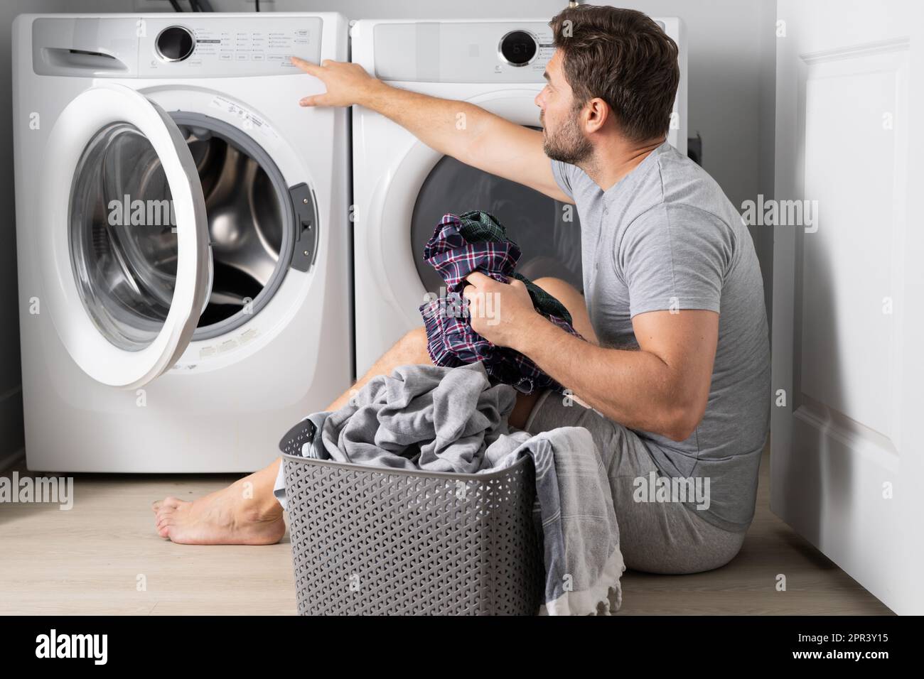 Middle aged single man with laundry basket and dirty clothes near ...