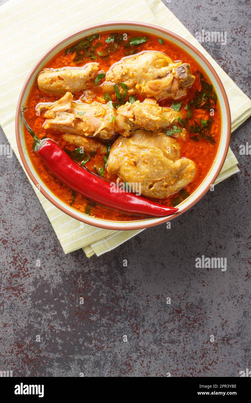 Spicy Indian Malvani Chicken Curry closeup on the bowl on the table ...