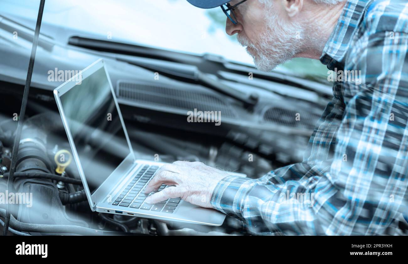 Car mechanic using laptop for checking car engine; light effect Stock ...