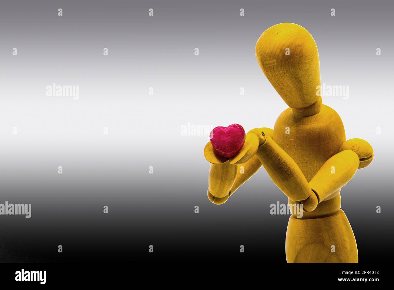 wooden mannequin offering a heart, I give you my heart Stock Photo - Alamy