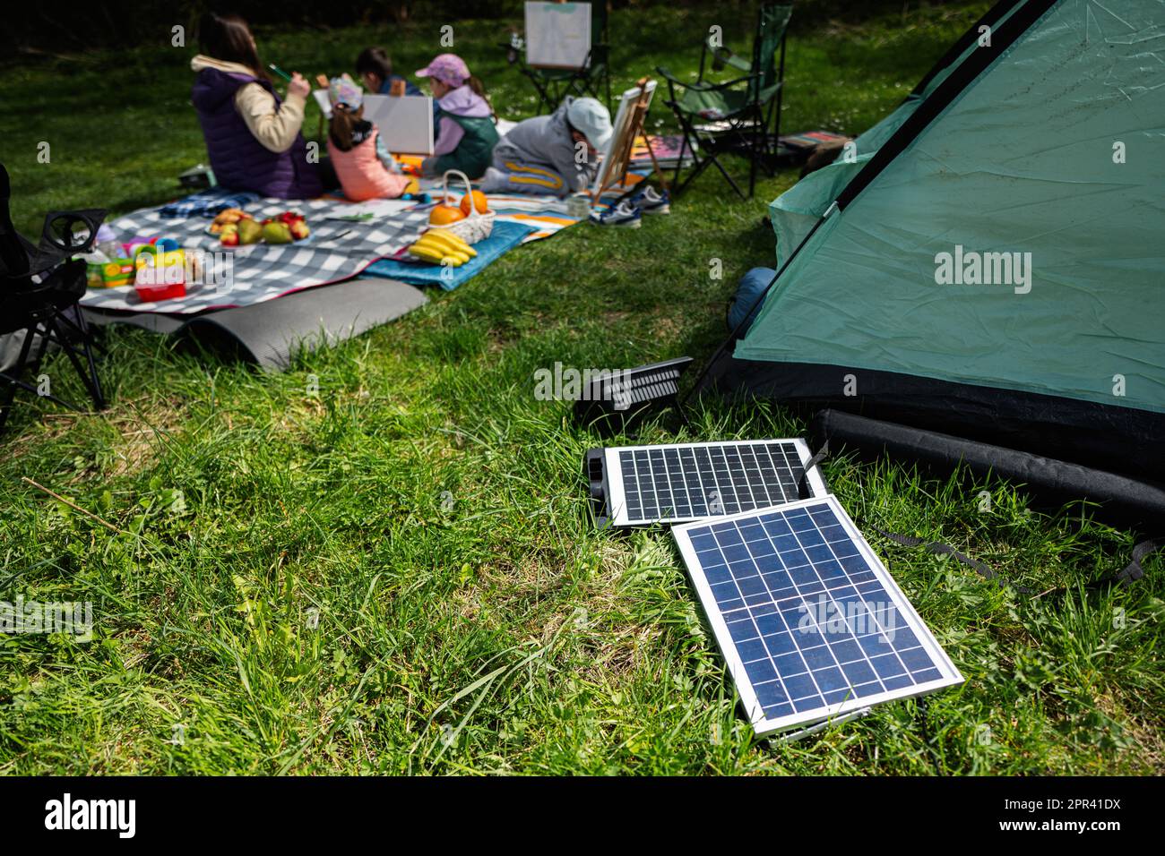Solar panels near tent. Happy young family, mother and children having ...