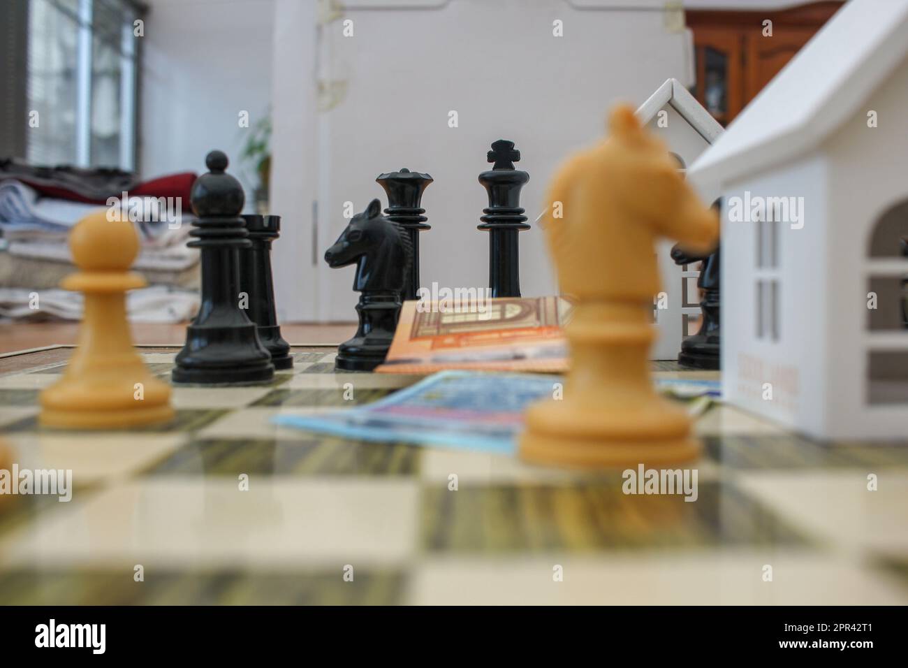 chess pieces, notes and a tiny house on the chessboard Stock Photo - Alamy