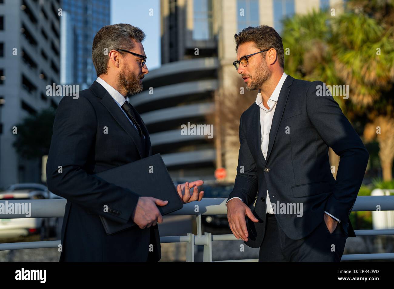Business communication. Two business men talking outdoors. Two diverse ...