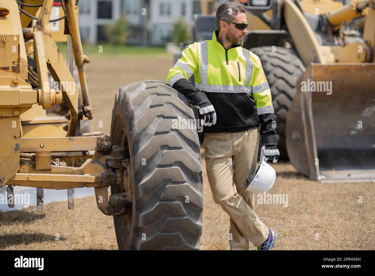 Machinery builder at buildings background. Excavator loader tractor and ...