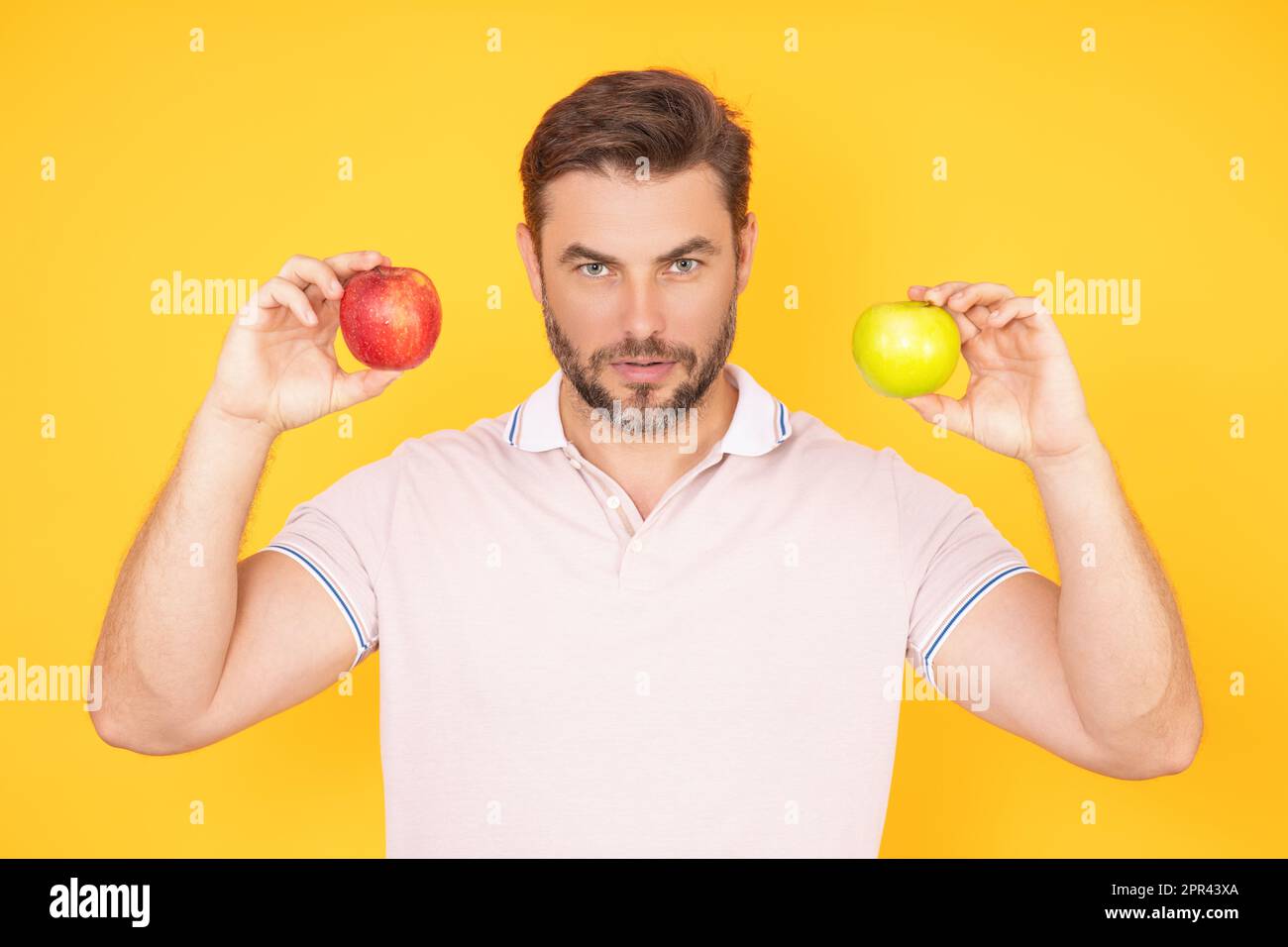 People with apple. Portrait of man eating apple isolated over studio ...