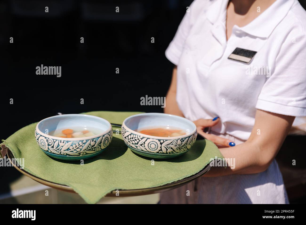 Middle selection of waitress hold two portion of soup on a tray. Fresh ...