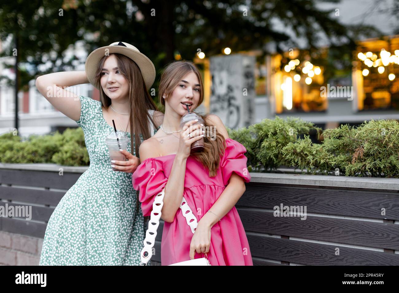 Two young beautiful smiling female in trendy summer clothes. Carefree women posing outdoors ...