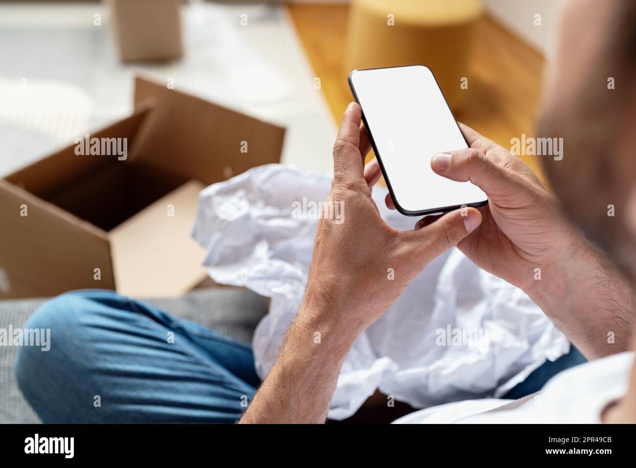 Man using smartphone opening parcel hi-res stock photography and images - Alamy