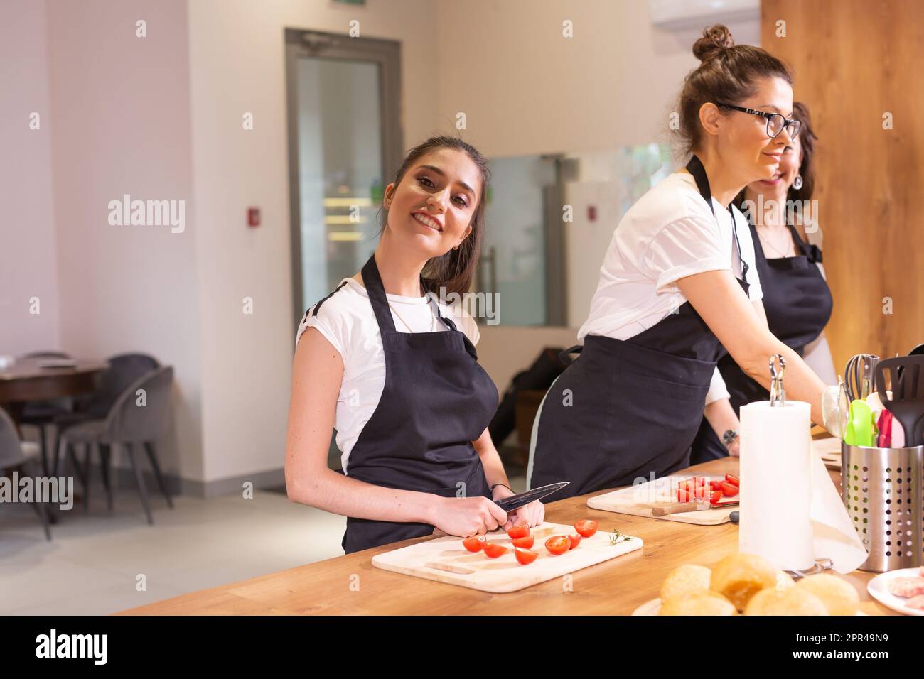 Cooking course - chef in cook uniform teaches young people cooking ...