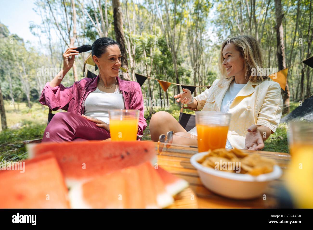 Four international friends having a party during summer in the nature ...