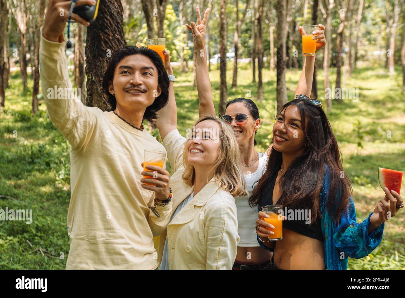 Four international friends having a party during summer in the nature ...