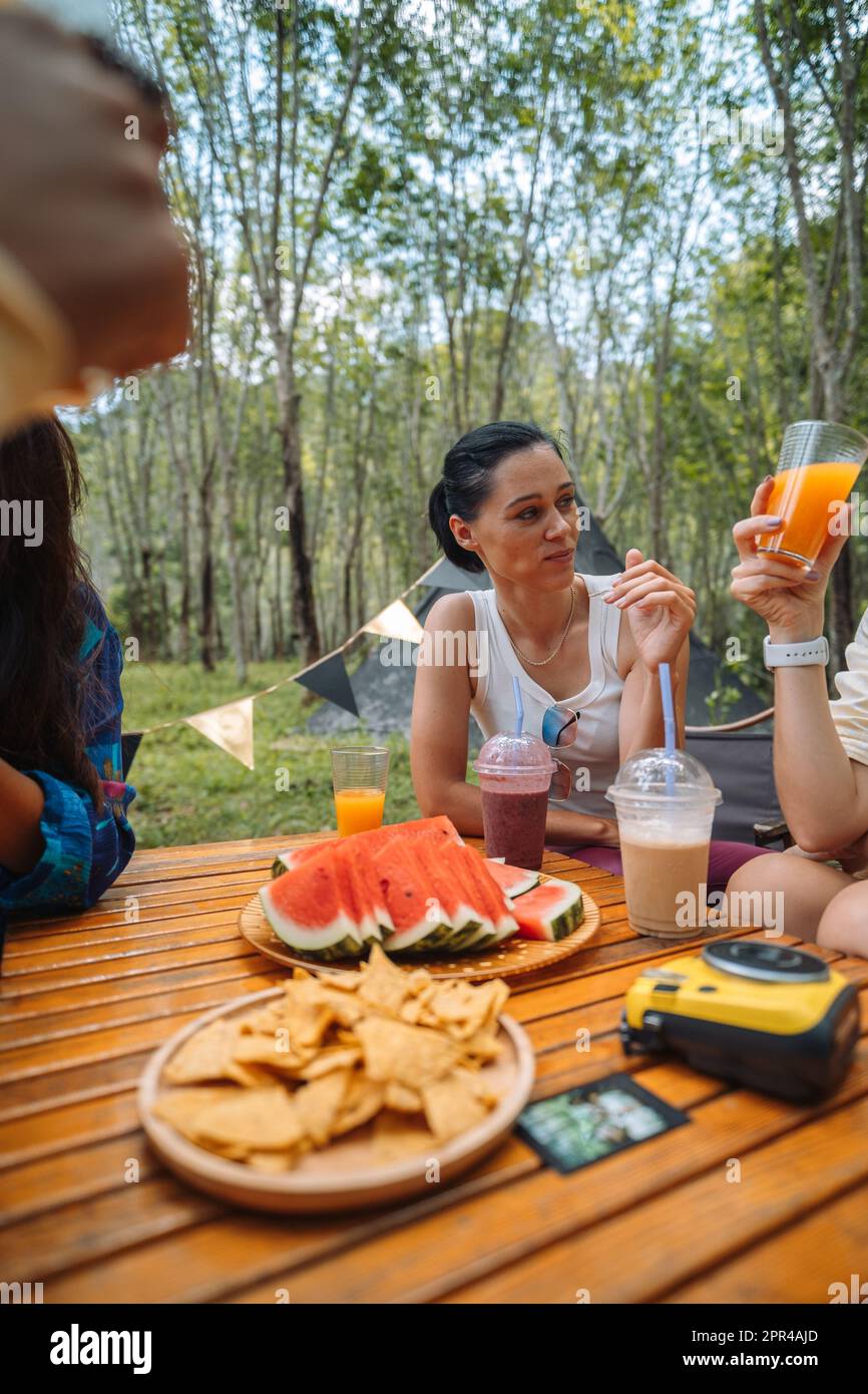 Four international friends having a party during summer in the nature ...