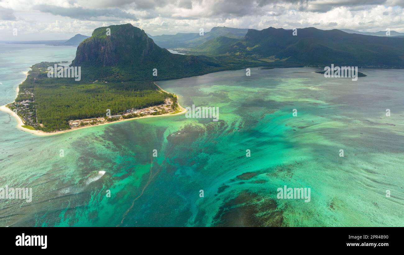 A lush tropical island with crystal clear blue water surrounding it ...