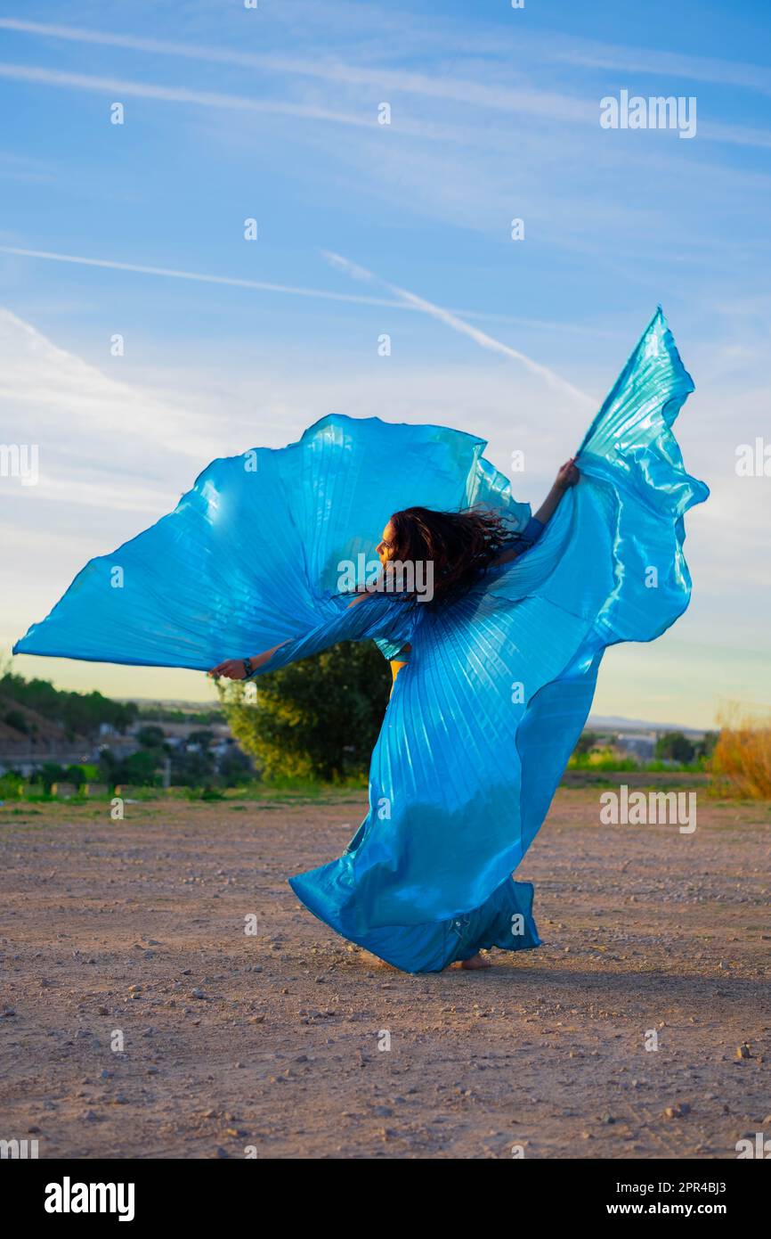 Oriental dancer dressed in blue with Isis Wings of the same color ...