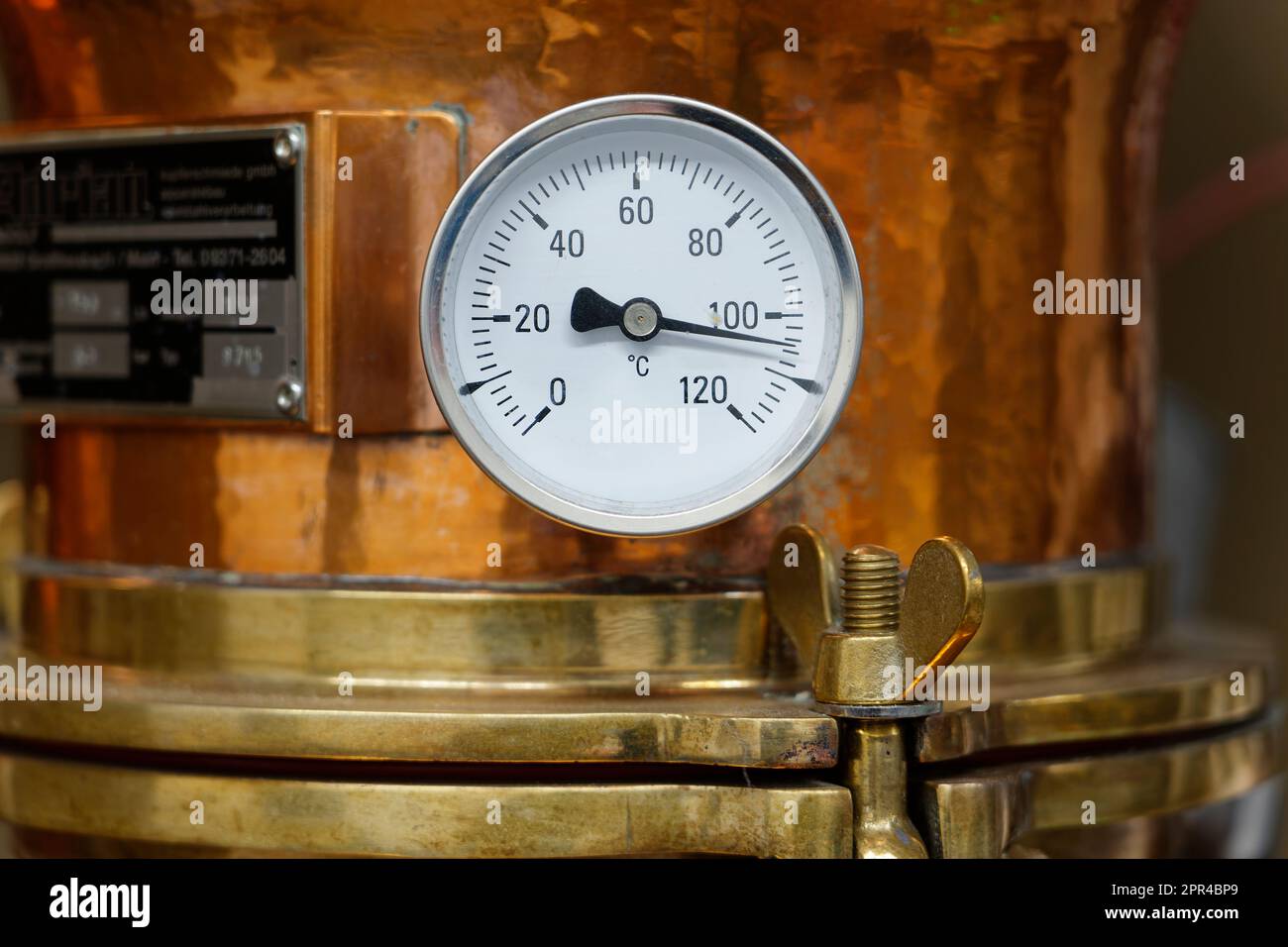 Close-up of a thermometer on a copper distillation pot with fastening ...