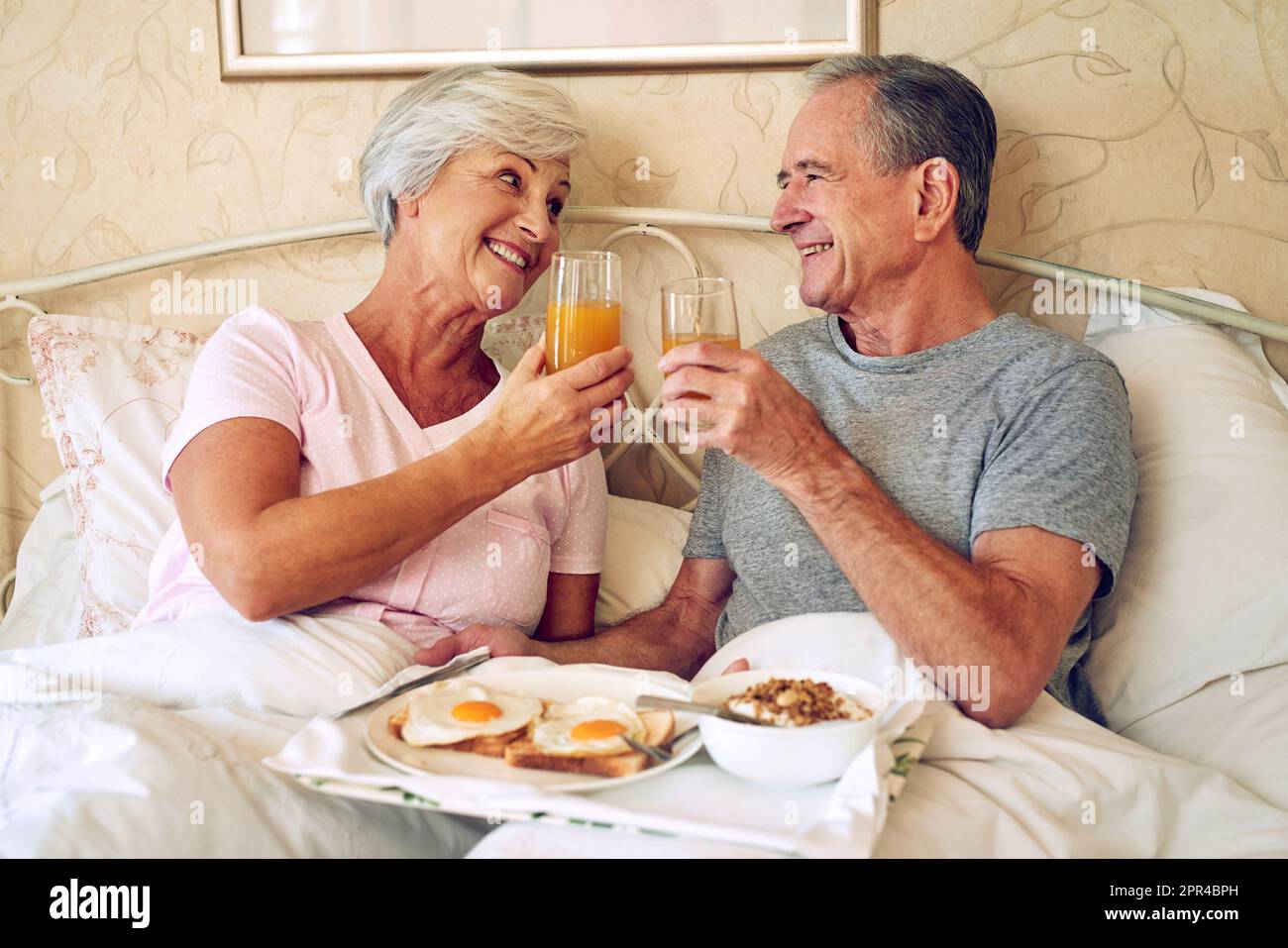 Cheers to you, my dear. a senior couple having breakfast in bed ...