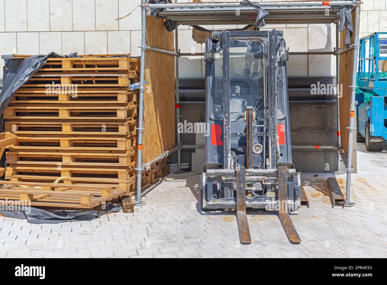 Forklift in Improvised Cover Temporary Garage and Stack of Pallets at ...