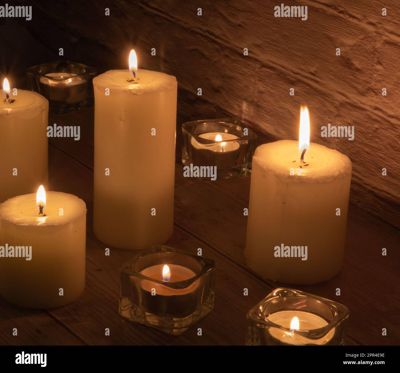 photo of many lit candles next to each other on the table Stock Photo ...