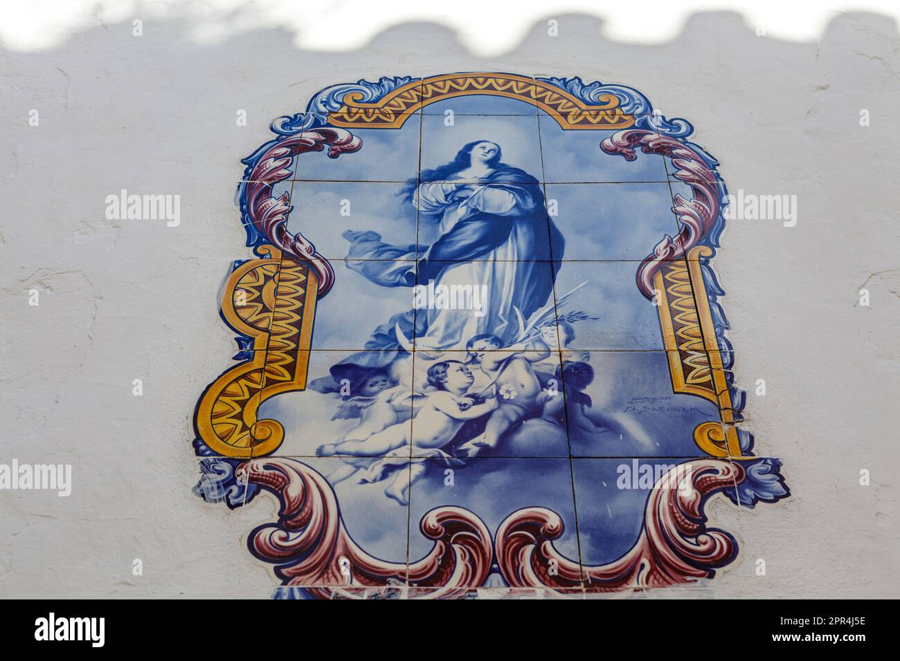 Portuguese tiles with Virgin Mary painting on a white wall of a ...