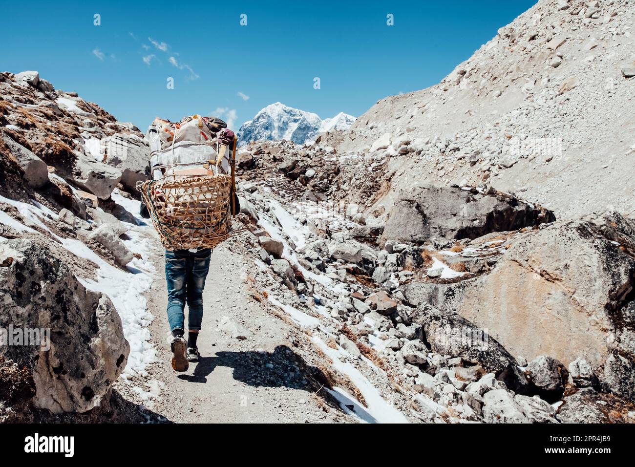 Nepalian Porter carrying heavy load on his back to Everest Base camp ...