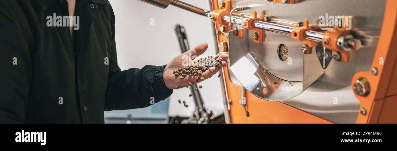 Business owner checks the quality of roasting coffee beans on small ...