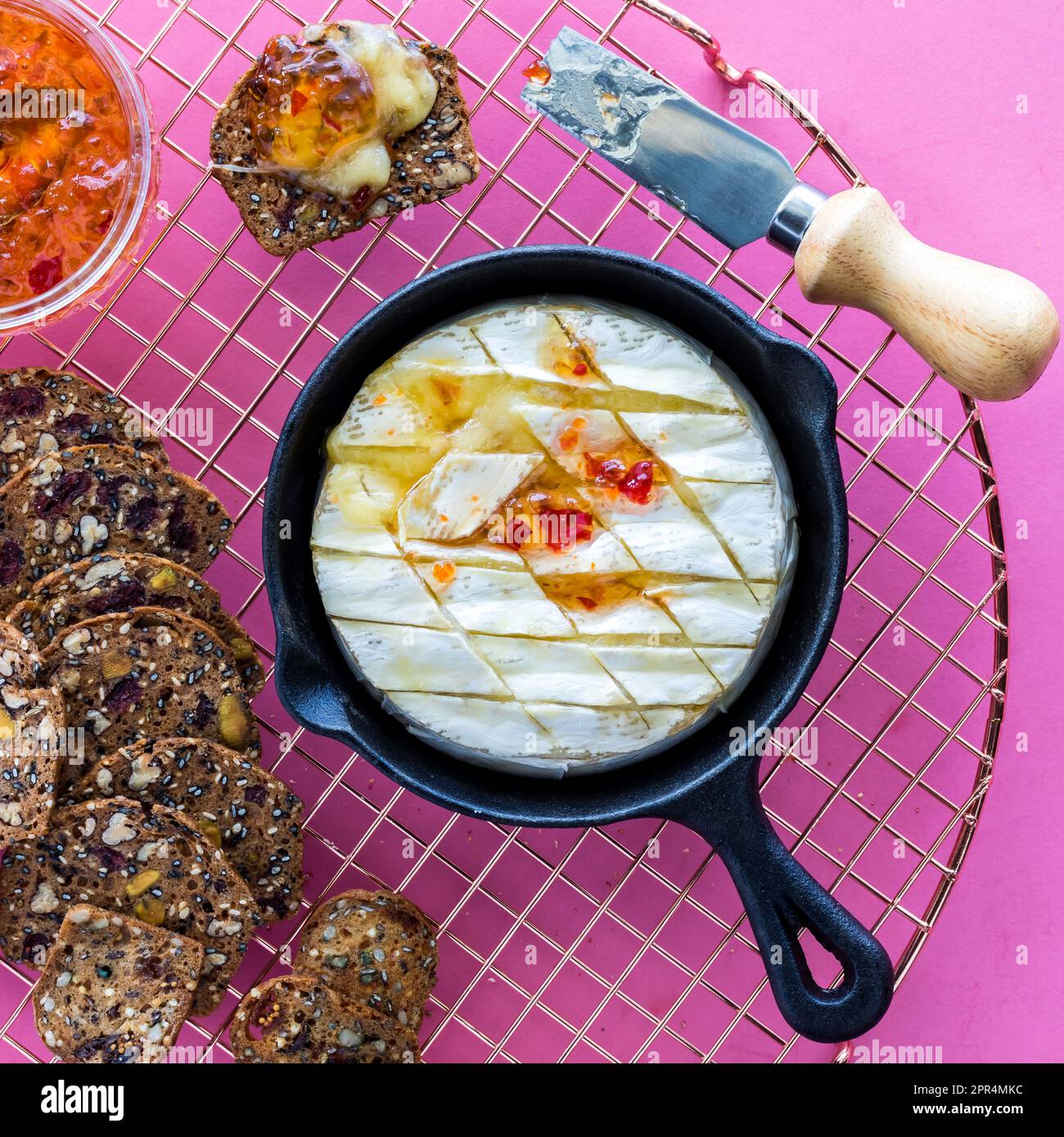 Top down view of a bake brie in a mini cast iron fry pan with red ...