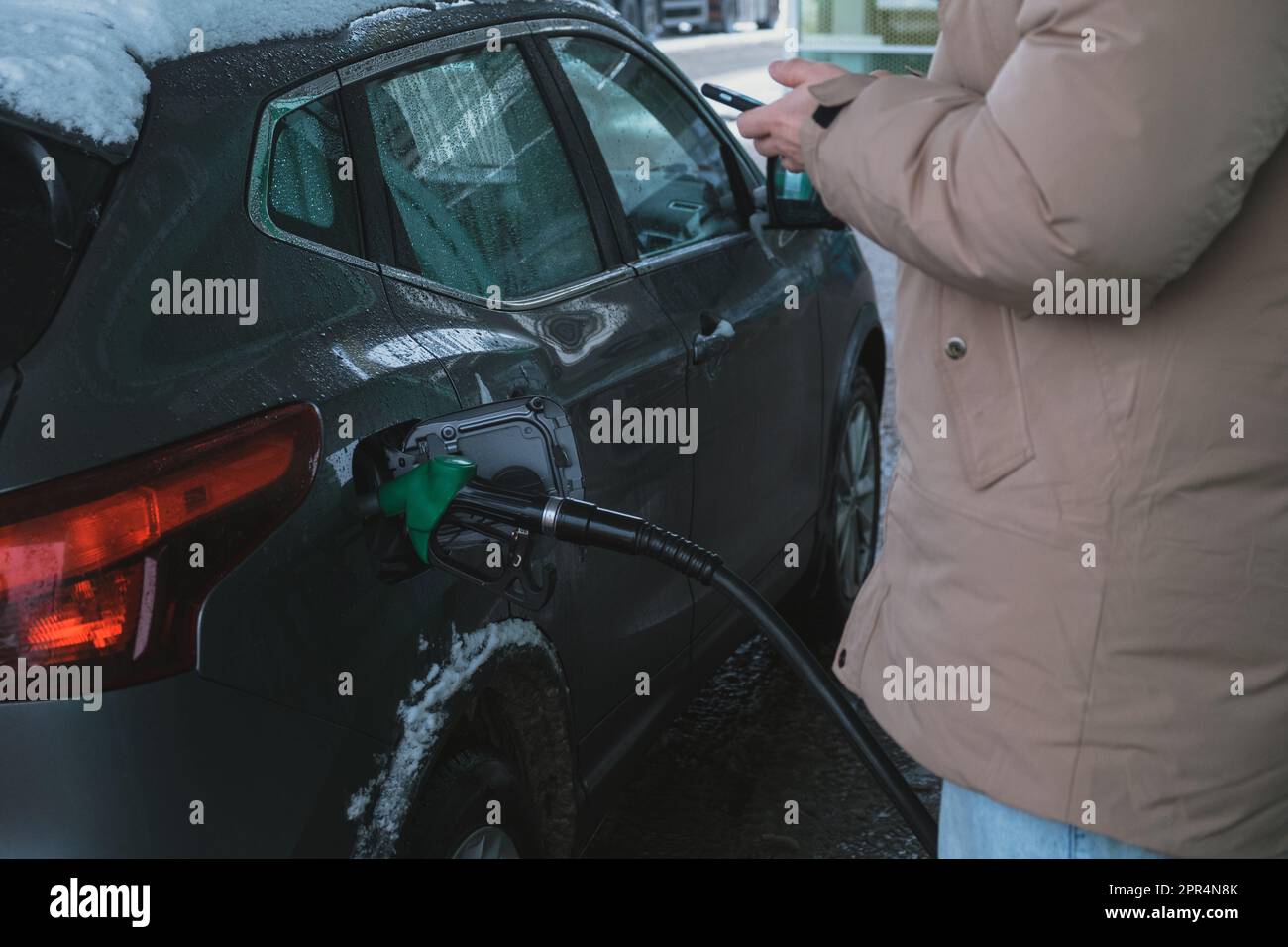 Using his phone, a guy fills up his car and pays for gas Stock Photo ...