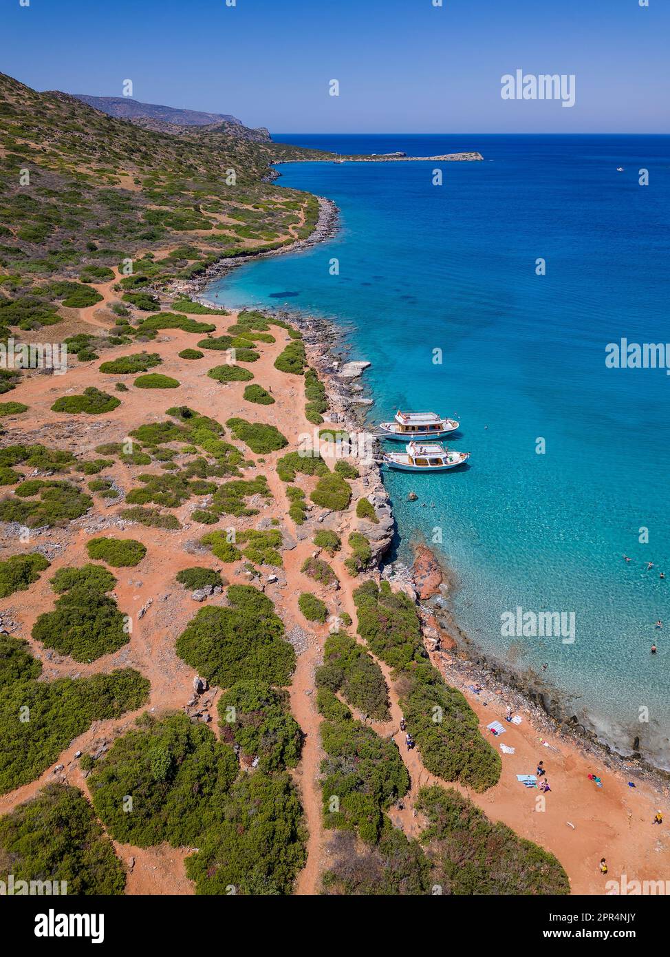 Aerial view of the clear waters and hot, dry coastline at a small beach ...