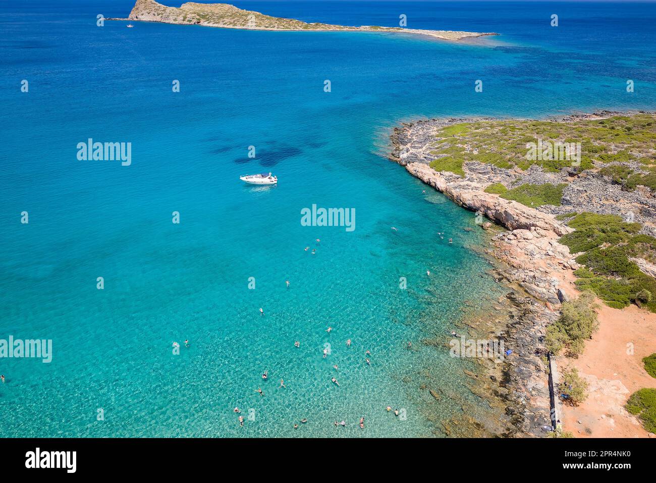 Aerial view of a small beach and clear, blue ocean on the Greek island ...