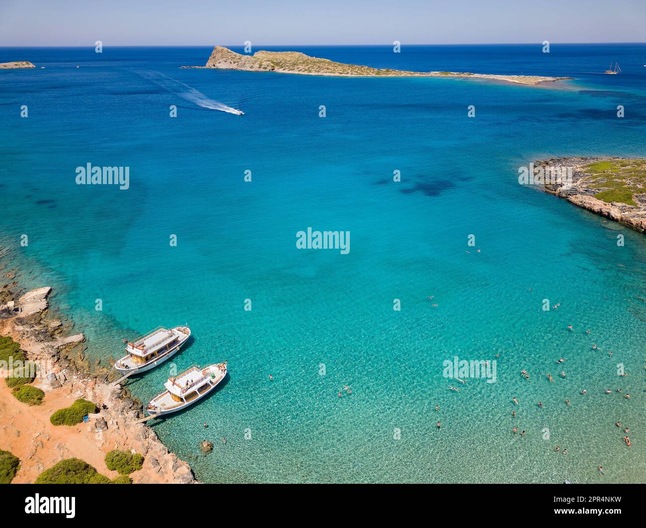 Aerial view of tourist boats and swimmers in crystal clear waters off a ...