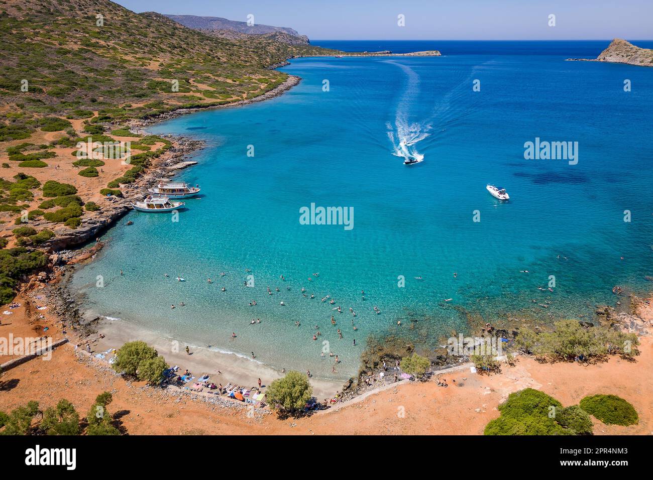 Aerial view of a small beach and clear, blue ocean on the Greek island ...