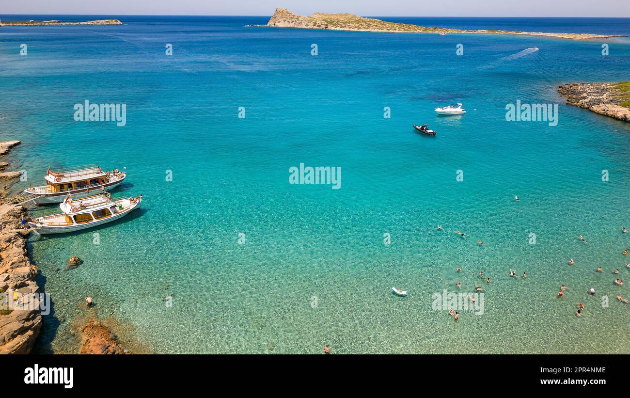Aerial view of tourist boats and swimmers in crystal clear waters off a ...