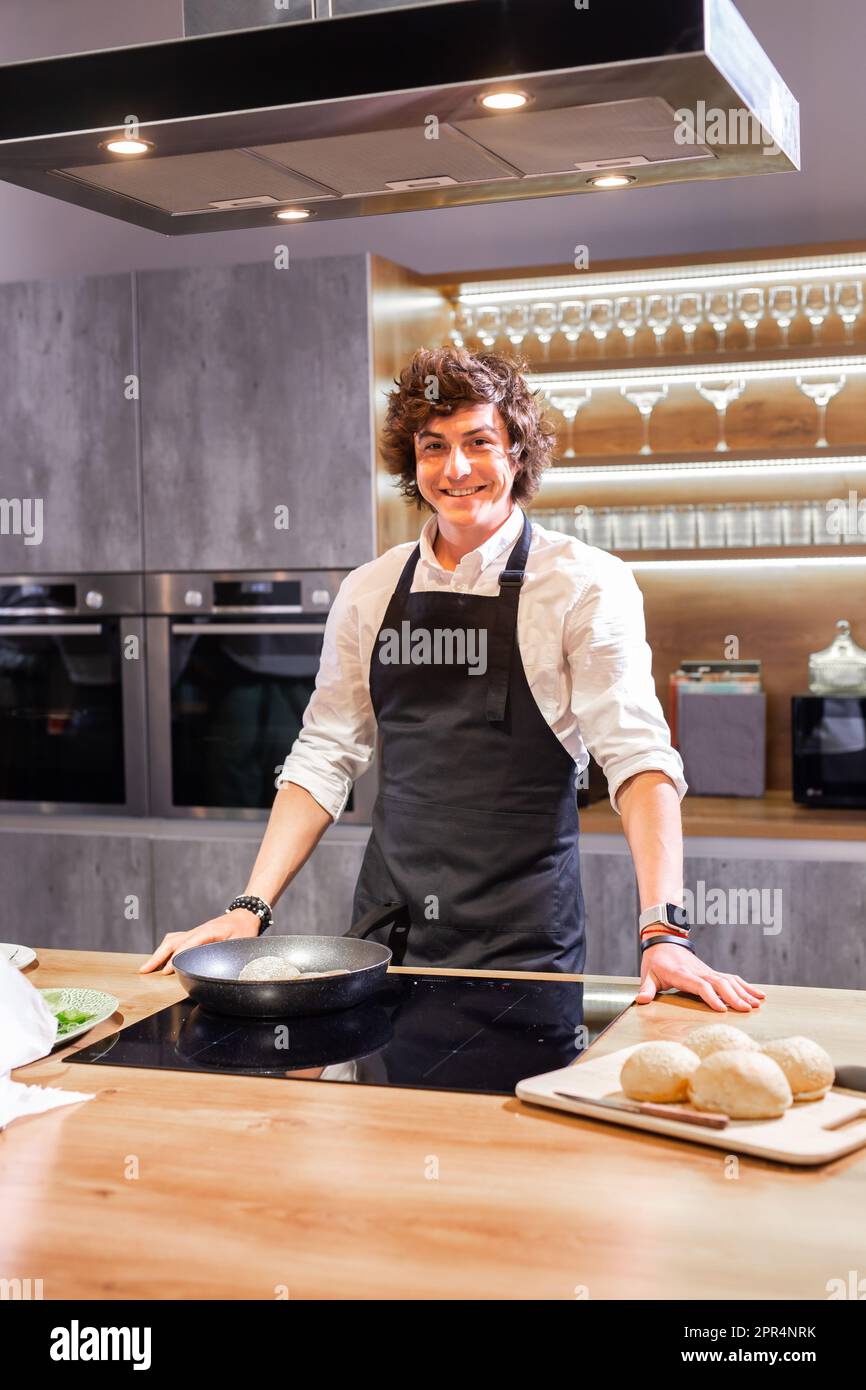 Portrait happy chef frying burger buns for a dinner party in the ...